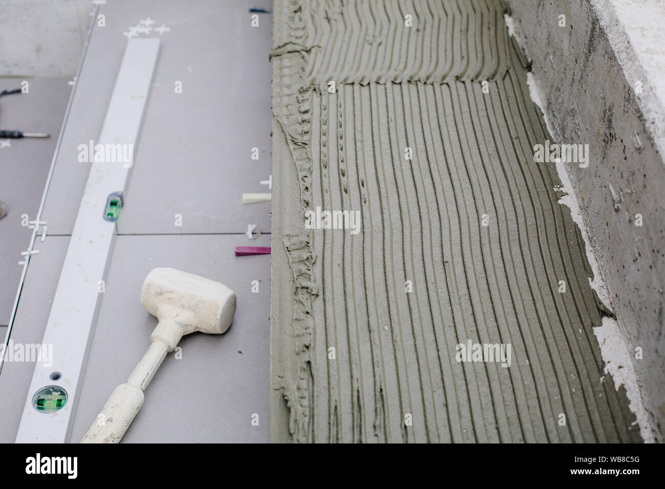 Laying new tiles on a concrete steps outside of a building Stock Photo ...