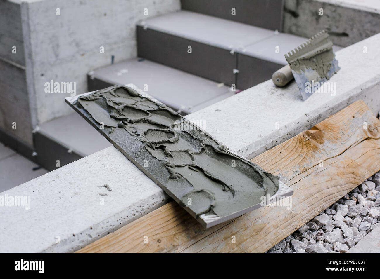 Laying new tiles on a concrete steps outside of a building Stock Photo ...