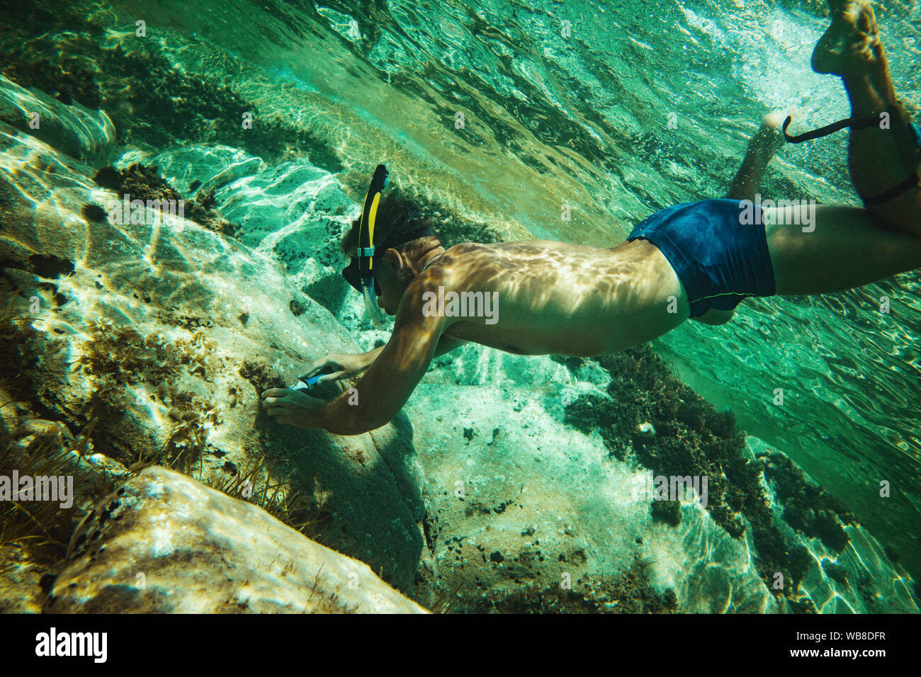 Handsome man having fun at summer vacation and exploring seafloor ...