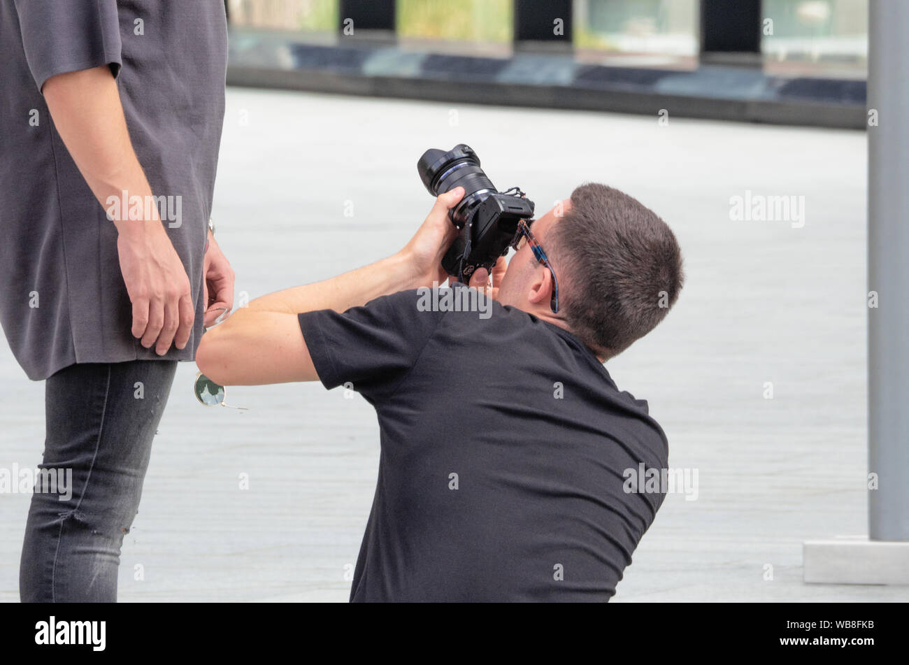 photographer crouched while performing a portrait Stock Photo - Alamy