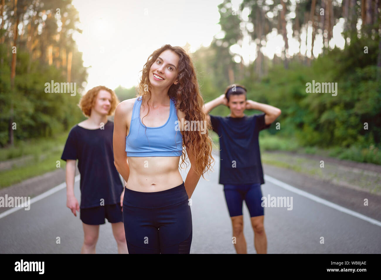 A group of three people athletes one girl and two men standing on ...