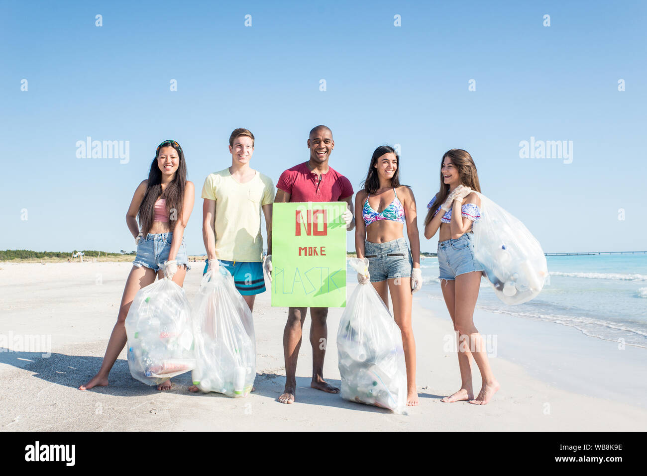 Group of activists friends collecting plastic waste on the beach ...