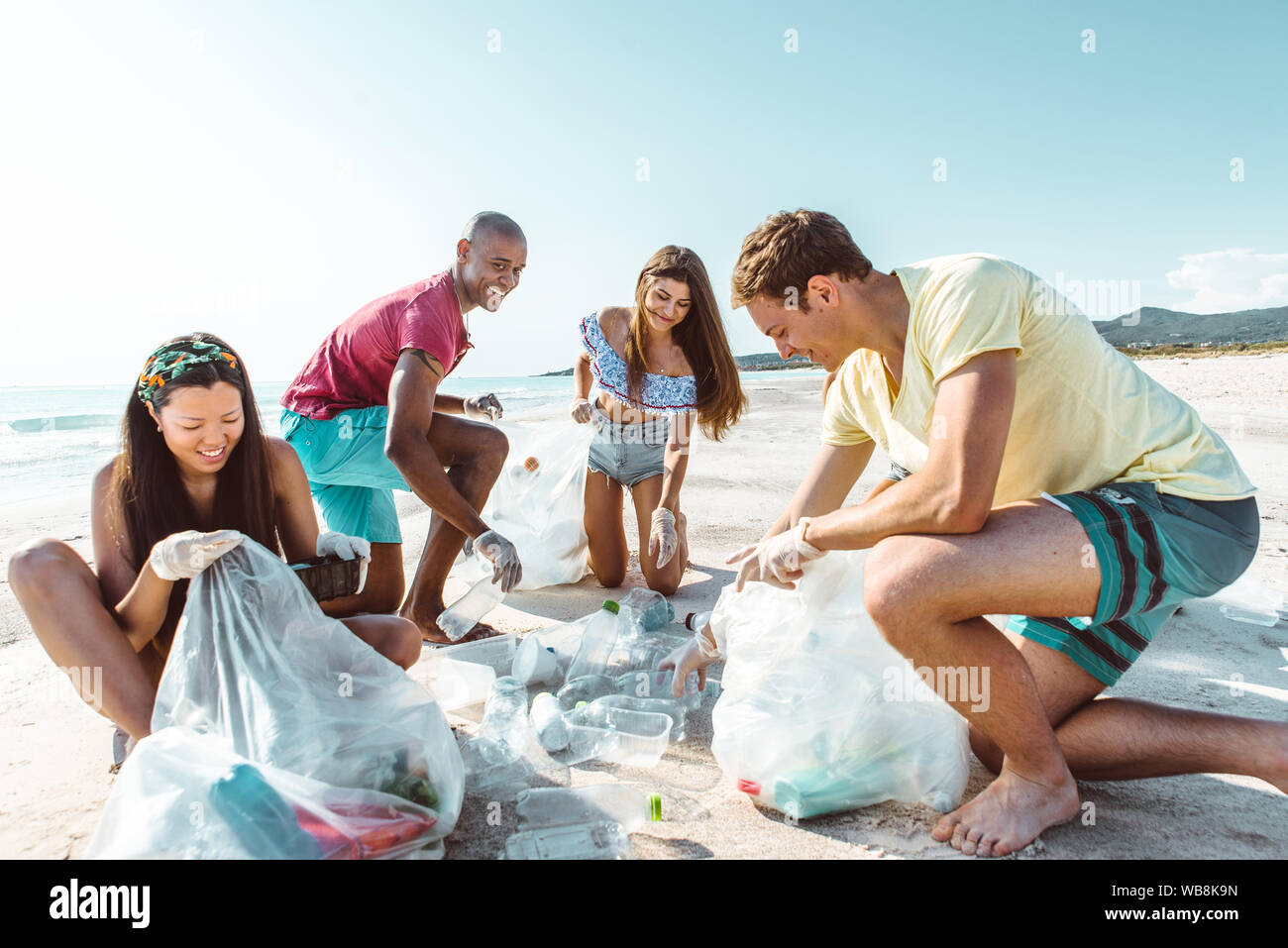 People Recycling On Beach