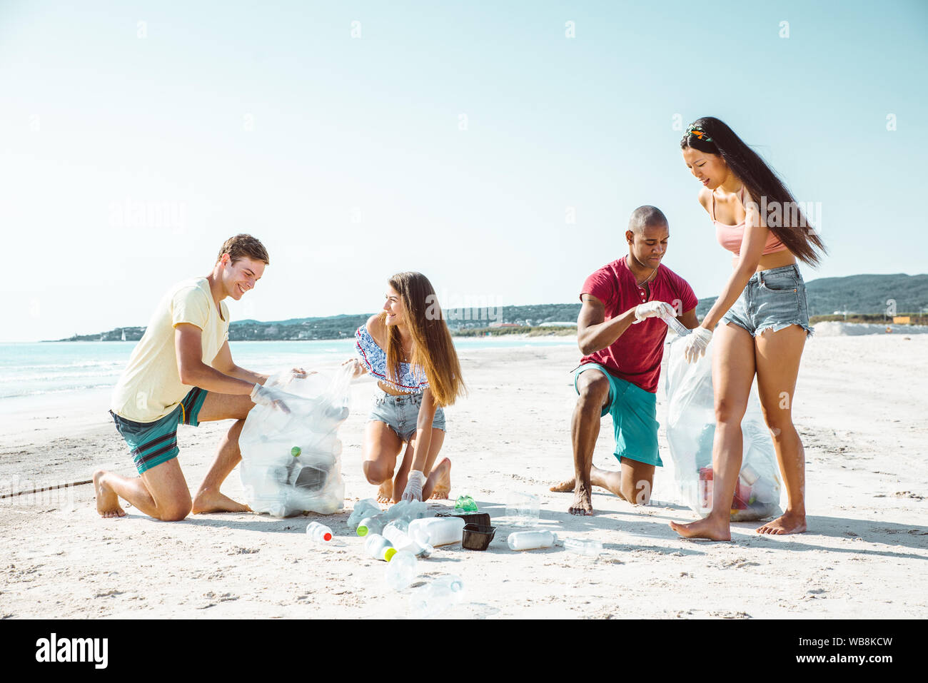 Group of activists friends collecting plastic waste on the beach ...