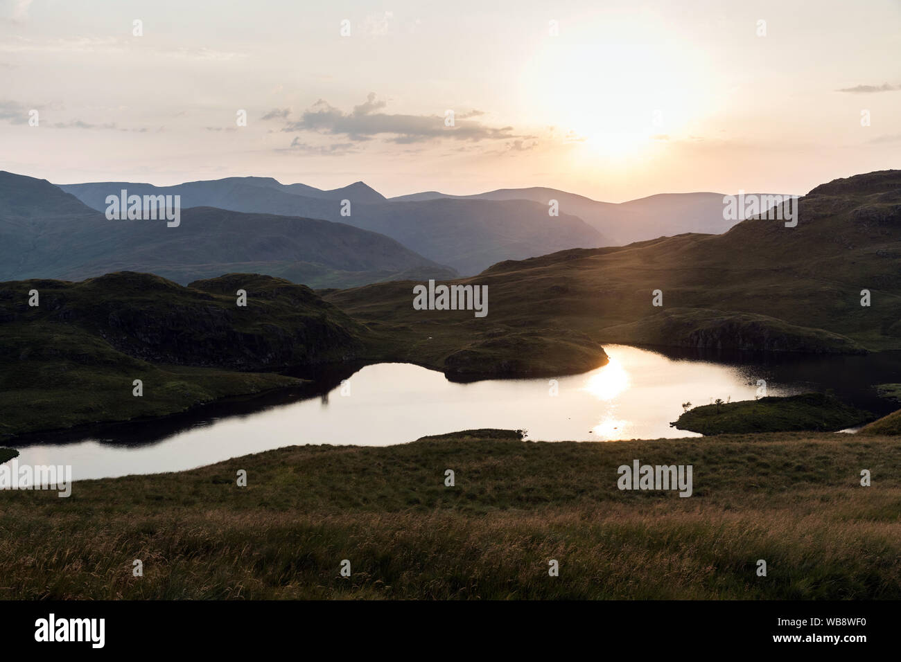 Sunset at Angle Tarn in the English Lake District. In the distance are ...