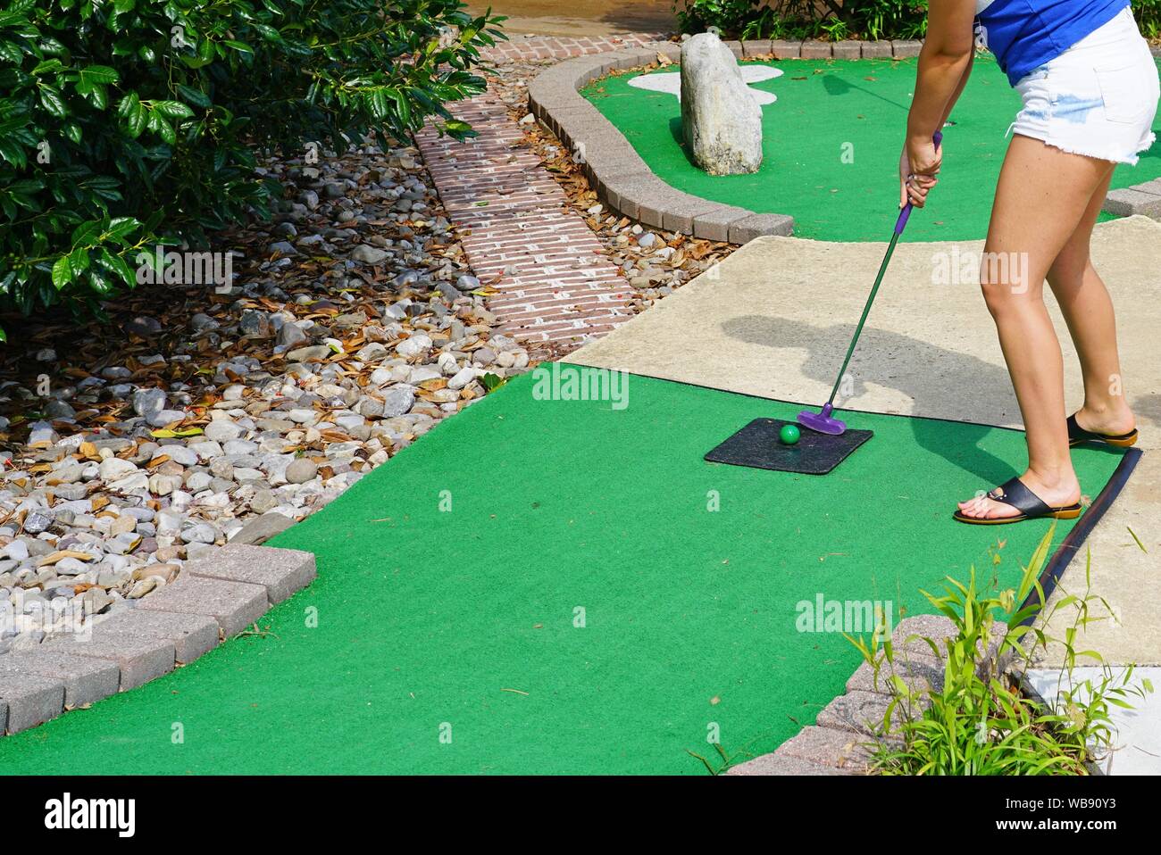 Playing mini-golf outdoors with a minigolf club Stock Photo - Alamy