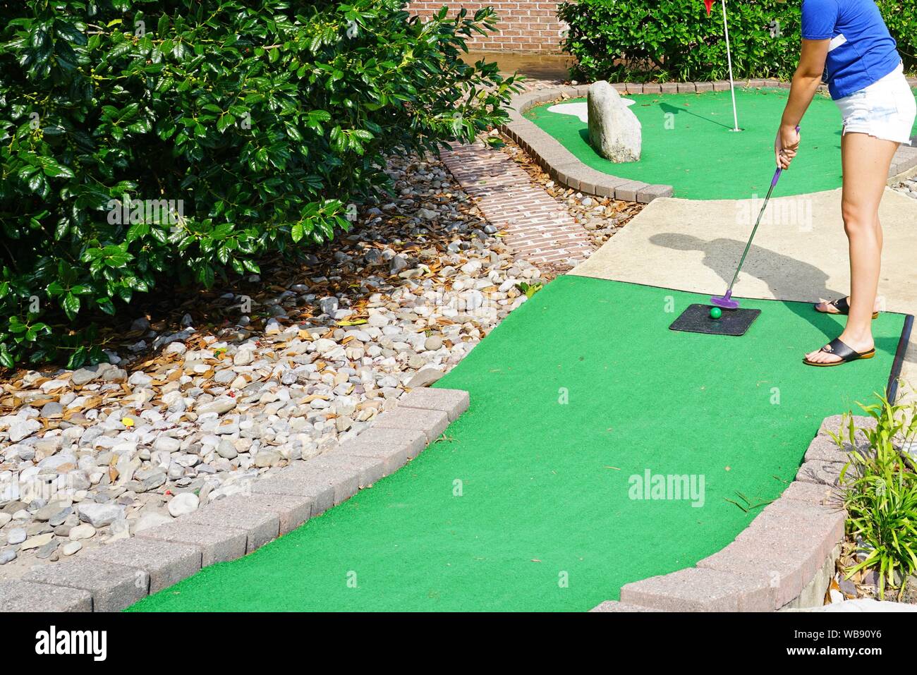 Playing mini-golf outdoors with a minigolf club Stock Photo - Alamy