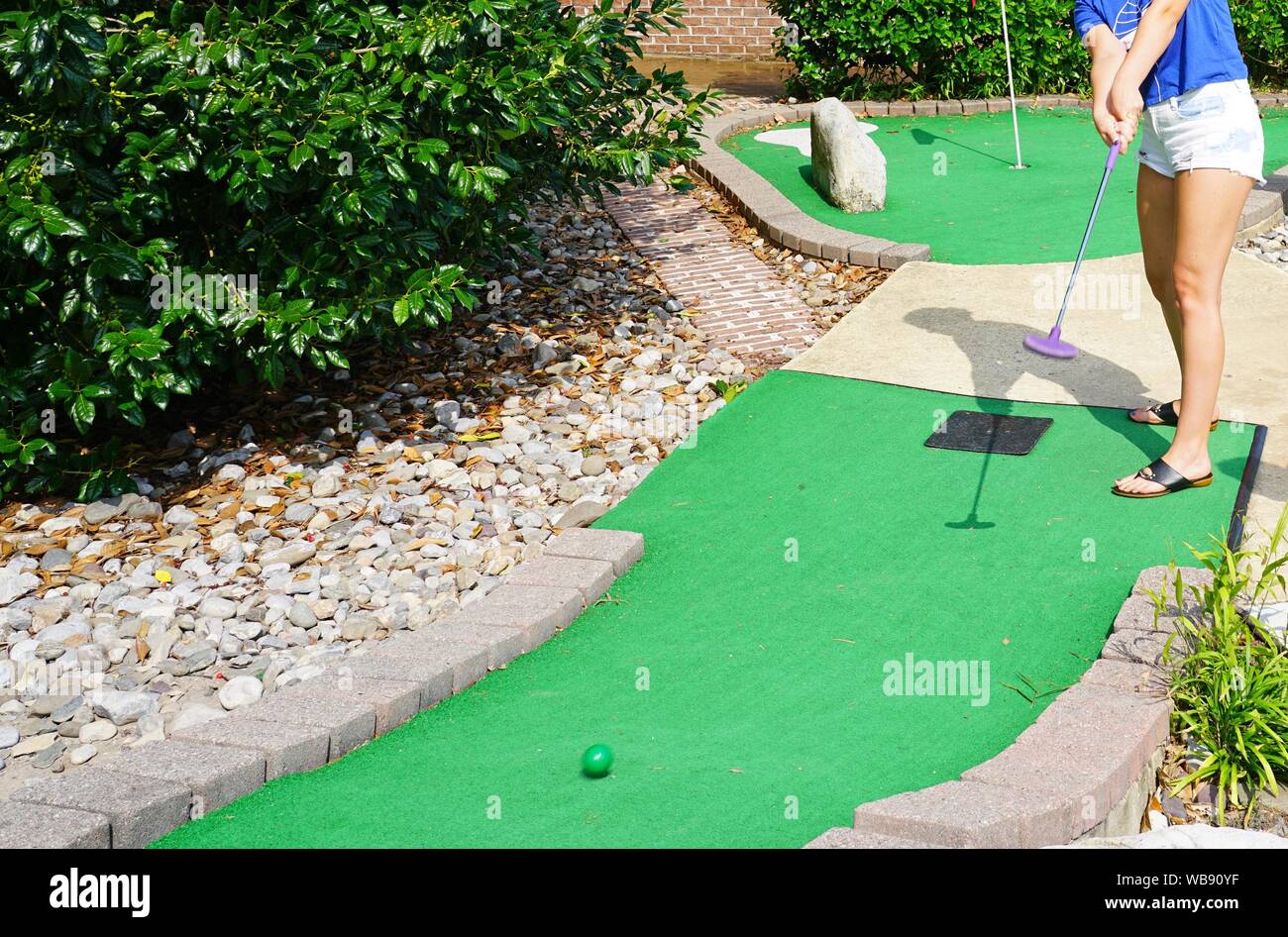 Playing mini-golf outdoors with a minigolf club Stock Photo - Alamy