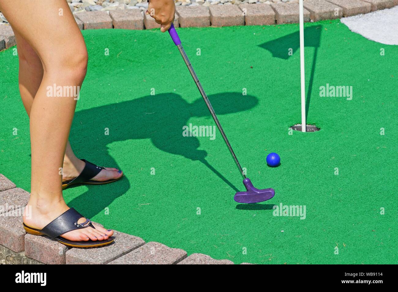 Playing mini-golf outdoors with a minigolf club Stock Photo - Alamy