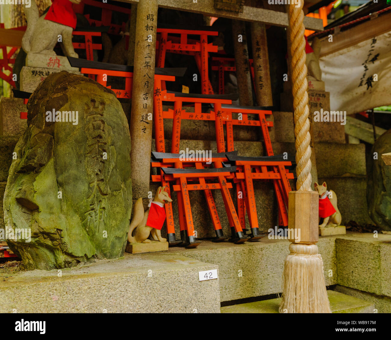 Minor side shrine with tiny vermilion torii gates in the forest of ...