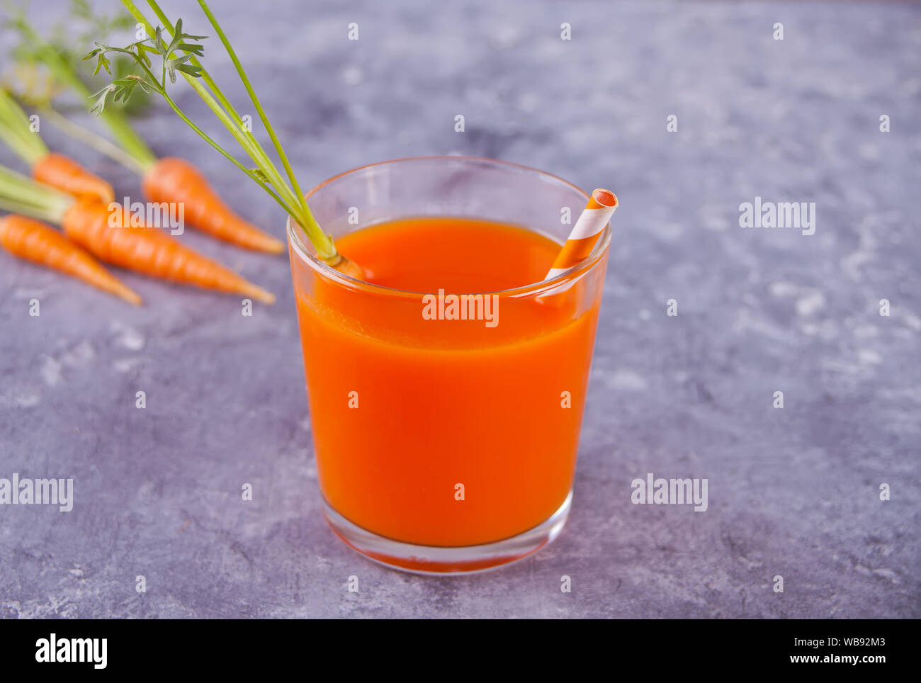 Carrot juice in glass on concrete background. Top view Stock Photo - Alamy