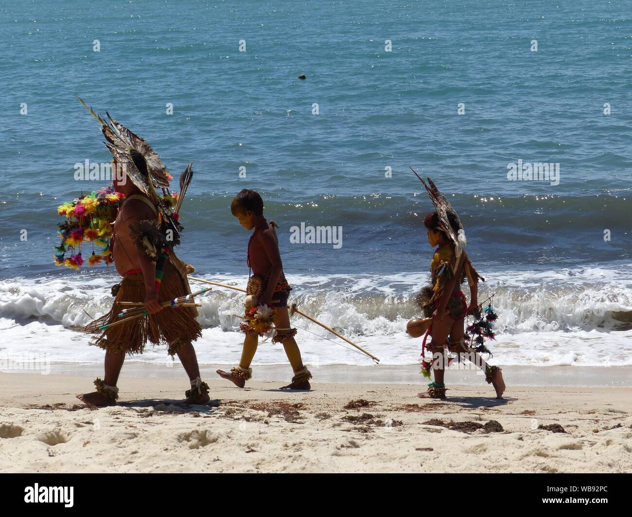 Indigenous Tupiniquim tribe people walking along the Taperapuã beach ...