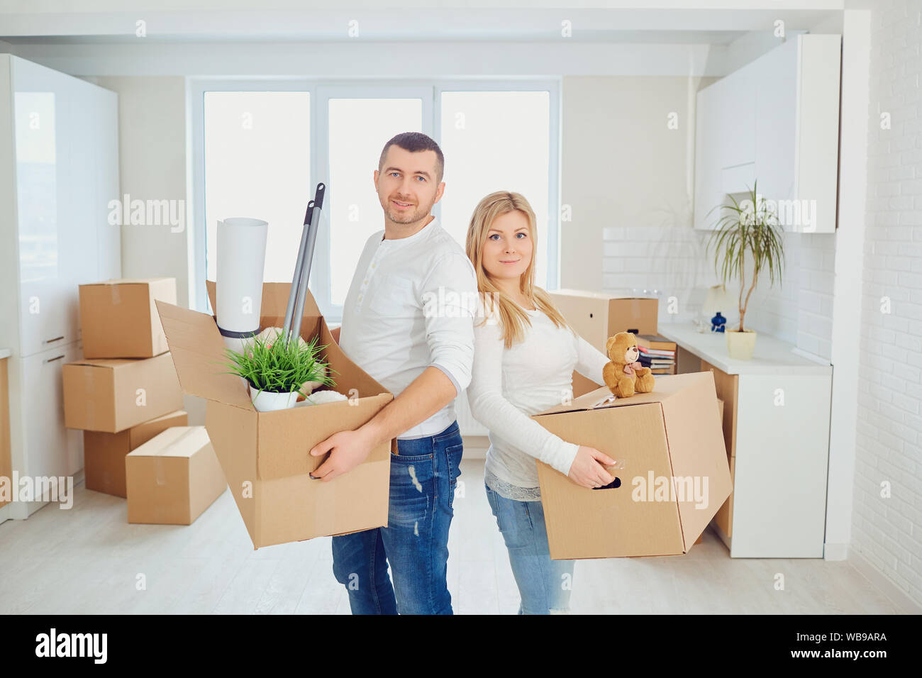 Happy family unpacking boxes at new home Stock Photo - Alamy