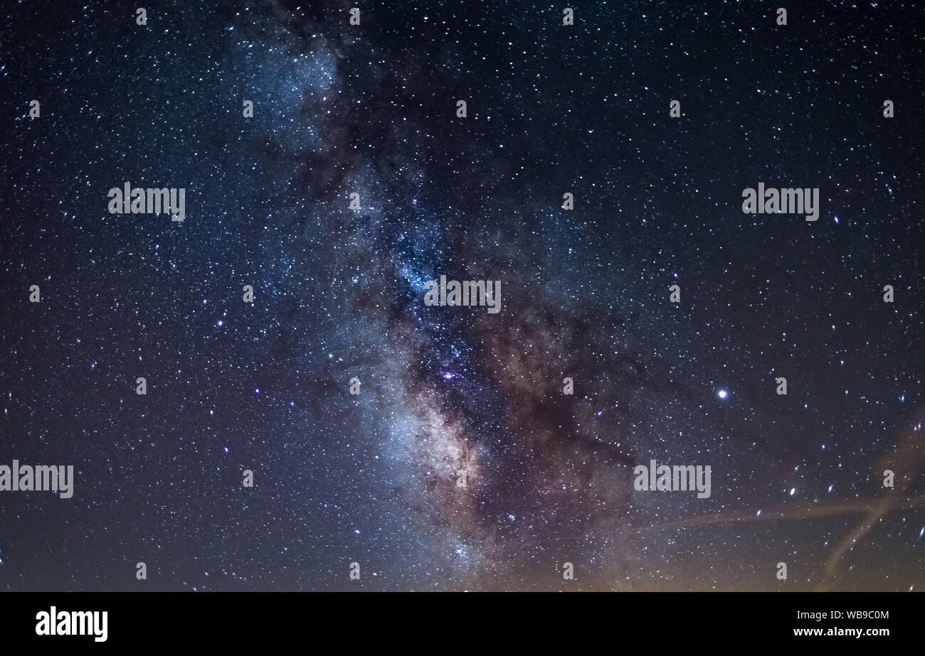 Milky way galaxy core and jupiter planet glowing in a bright starry ...