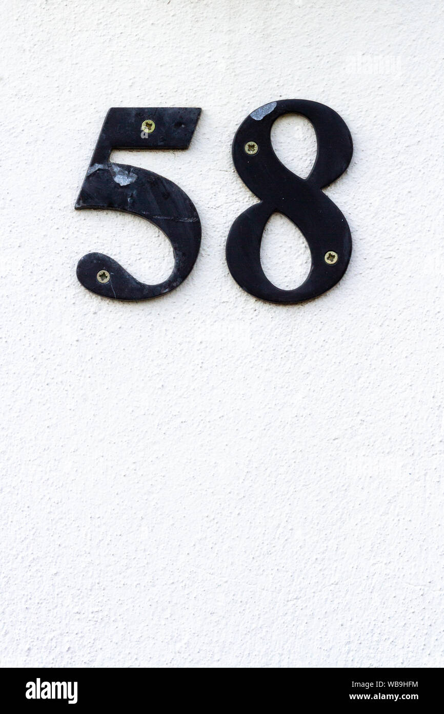 House number 58 in black metal on a white plaster wall Stock Photo - Alamy