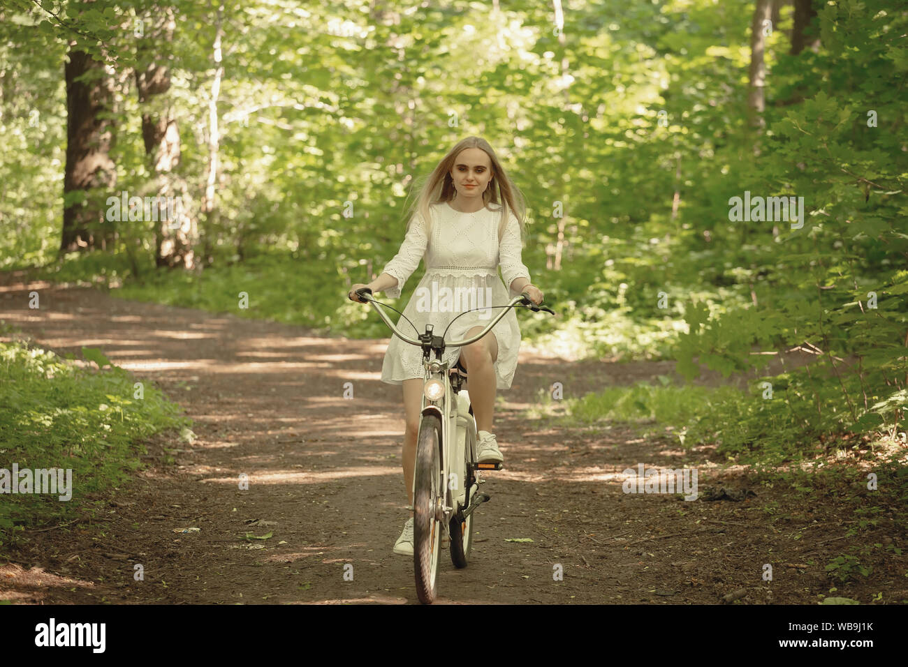 Girl with dress riding bike hi-res stock photography and images - Alamy
