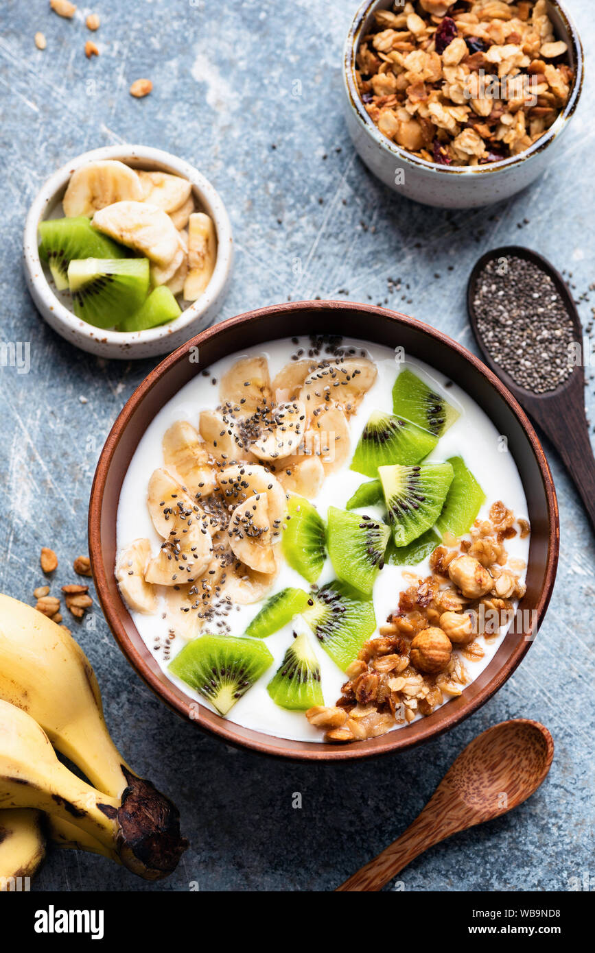 Breakfast yogurt bowl with fruits, granola, chia seeds. Table top view ...