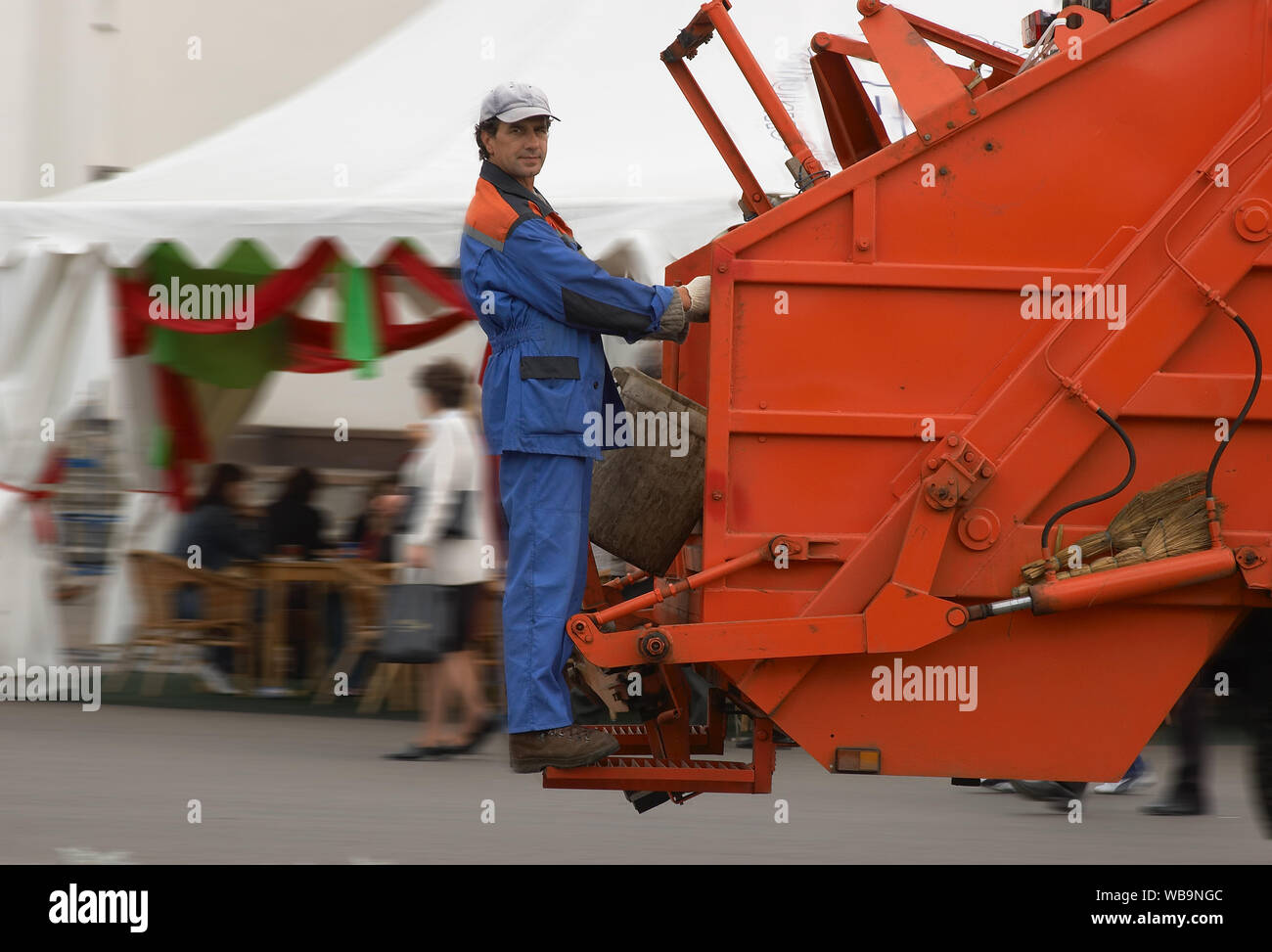 Worker riding on a garbage collecting truck Stock Photo - Alamy