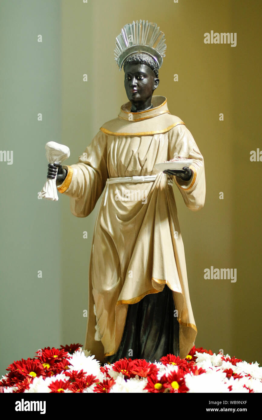 Statue with image of St. Benedict on altar decorated with flowers, OFM ...