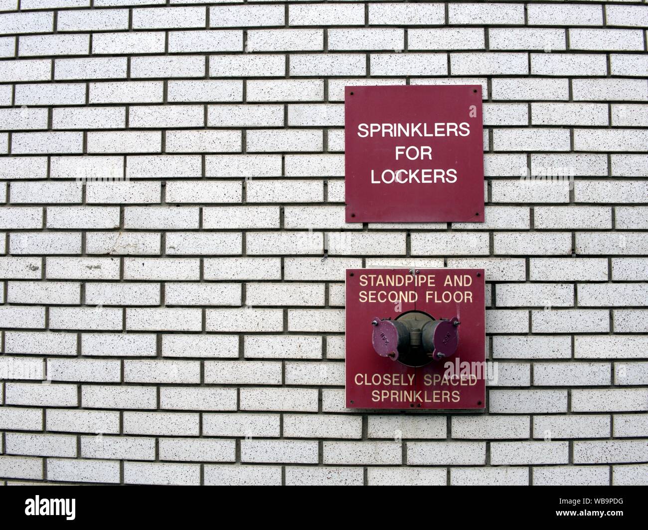 Signs for sprinklers and standpipe on the side of an apartment building ...