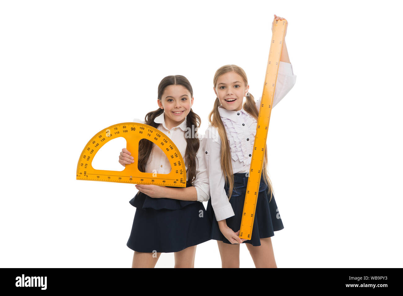 Being ready for lesson. Cute schoolgirls holding protractor and ruler ...