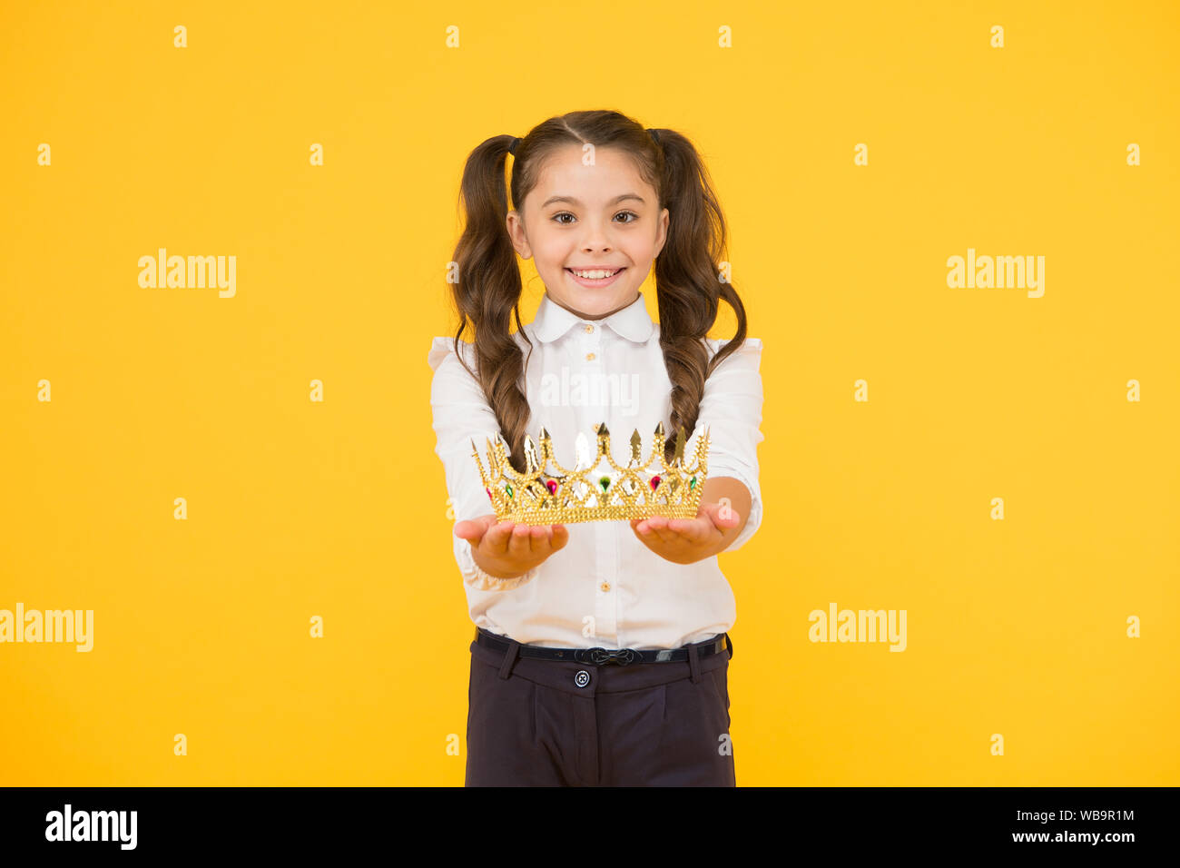 Best student prize reward. Happy small child giving out crown reward on ...