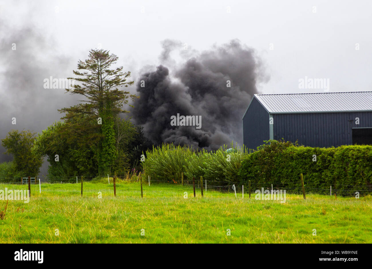Thick black acrid smoke from a farm fire causing pollution to the ...