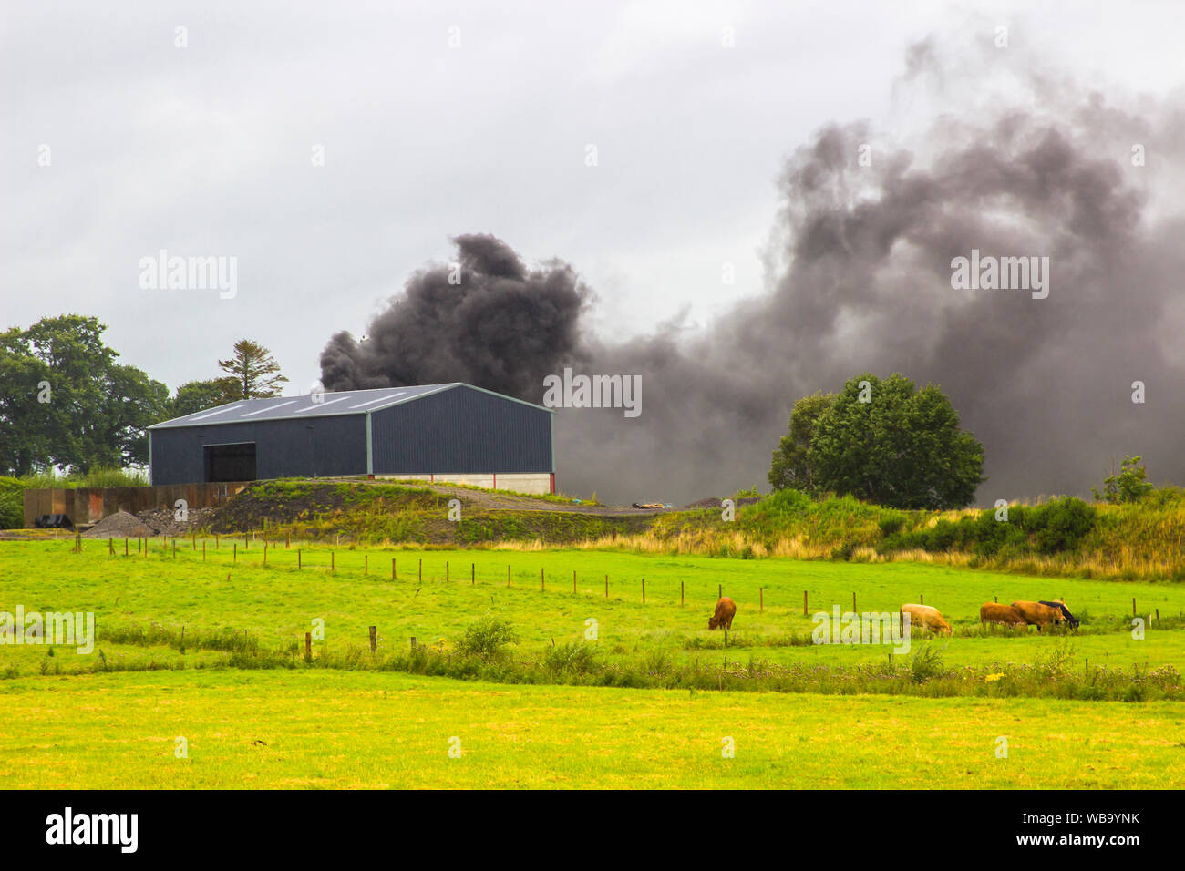 Thick black acrid smoke from a farm fire causing pollution to the ...