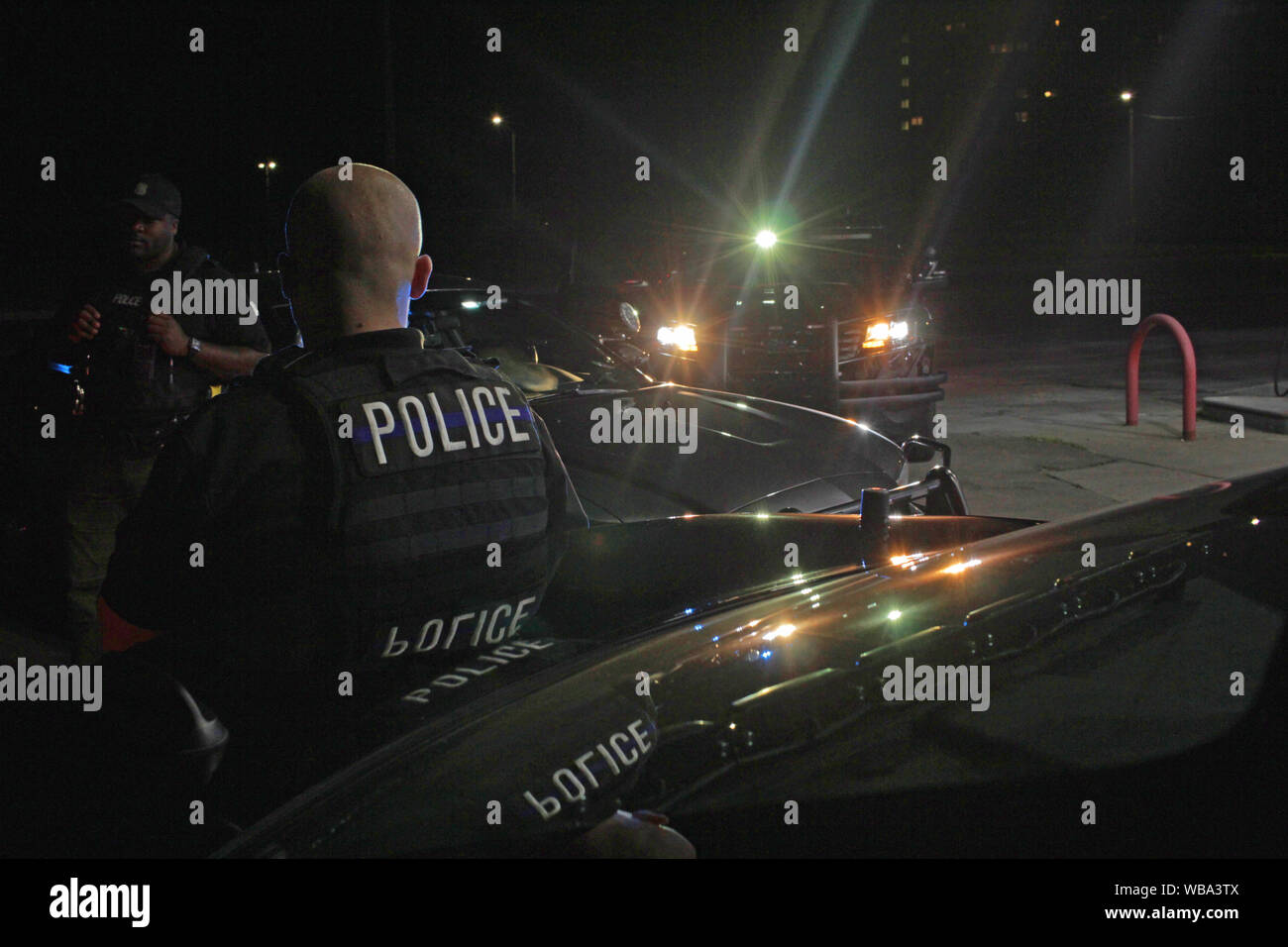 Detroit police officers speak at a gas station at night after dealing ...