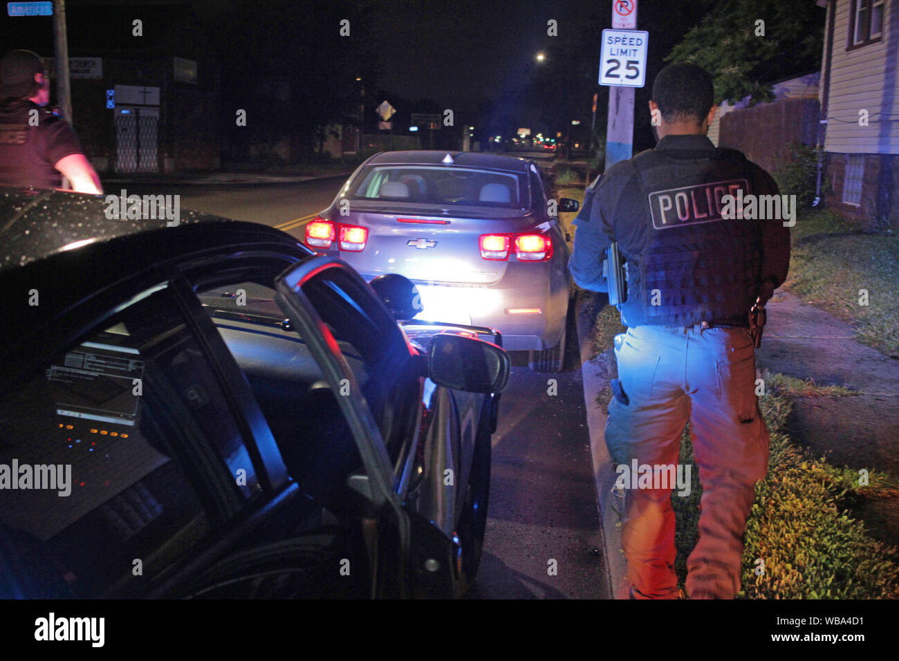 Police in Detroit stop a car at night to speak to the driver, Detroit ...