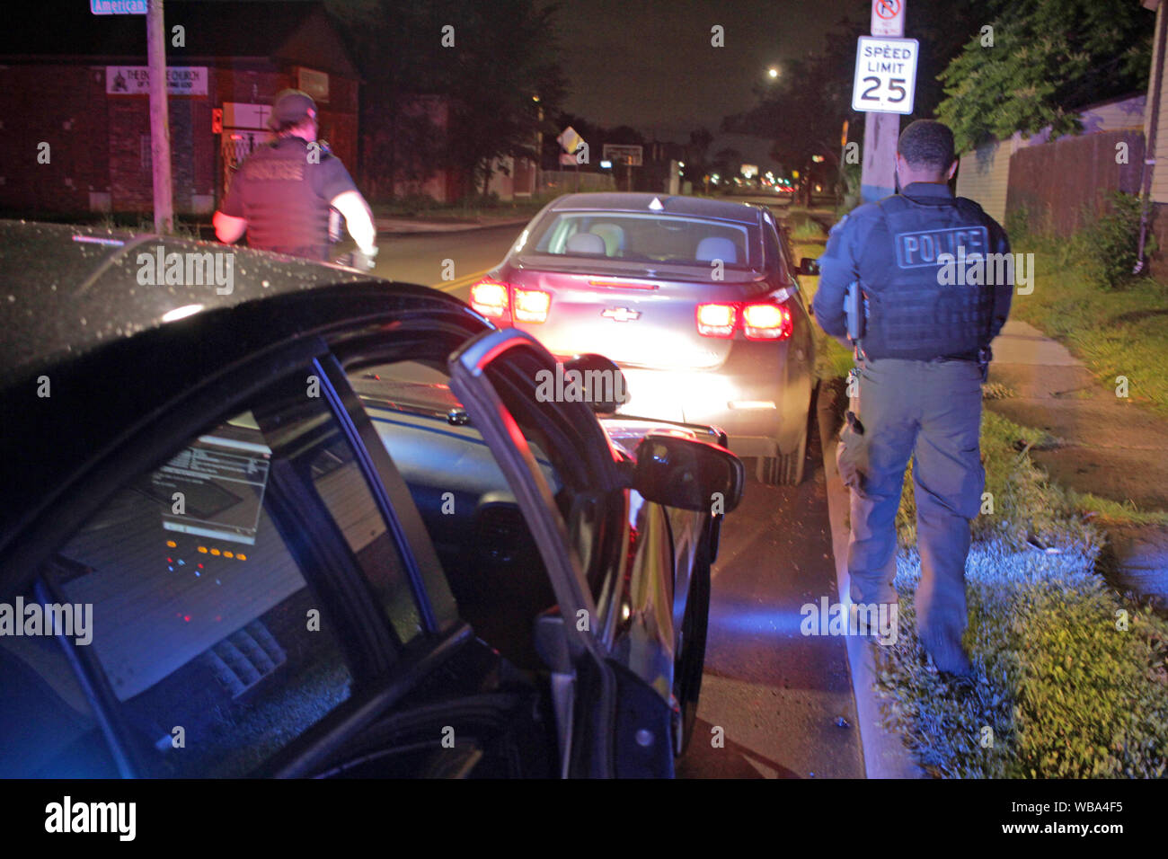 Police in Detroit stop a car at night to speak to the driver, Detroit ...