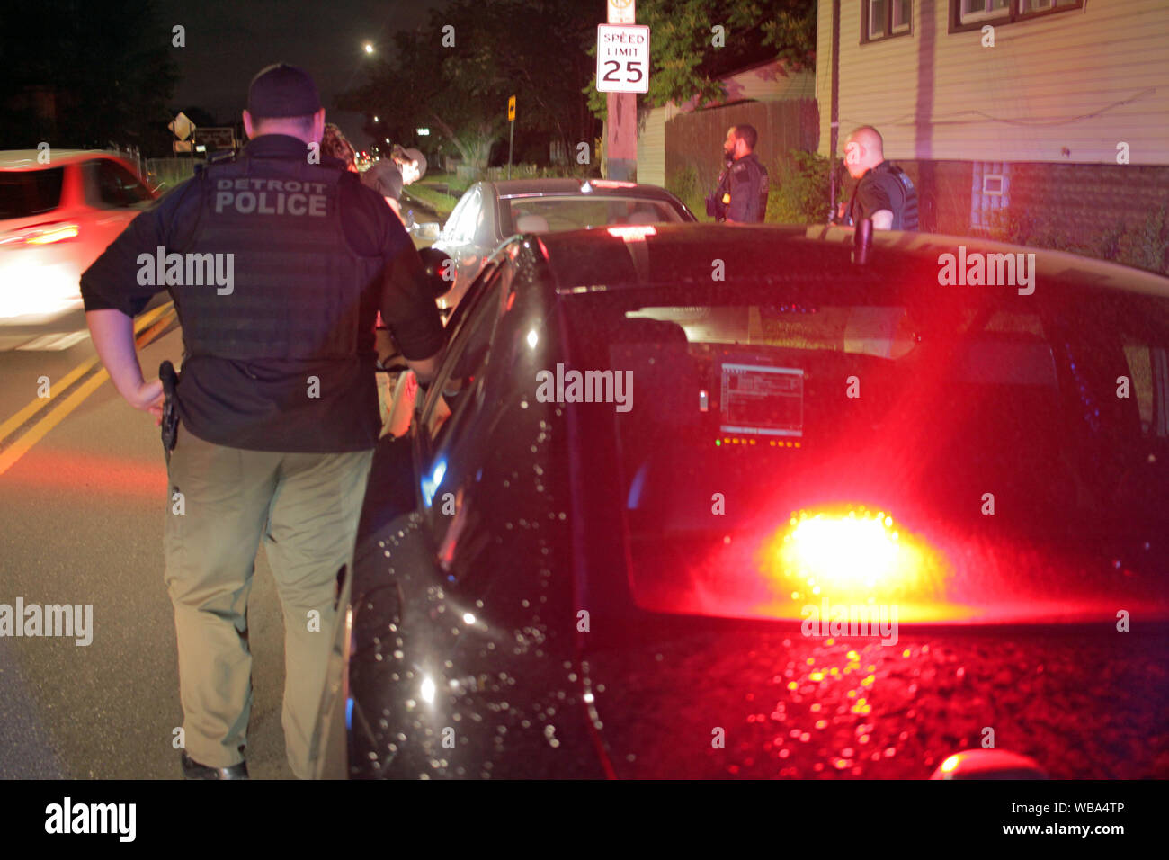 Police in Detroit stop a car at night to speak to the driver, Detroit ...