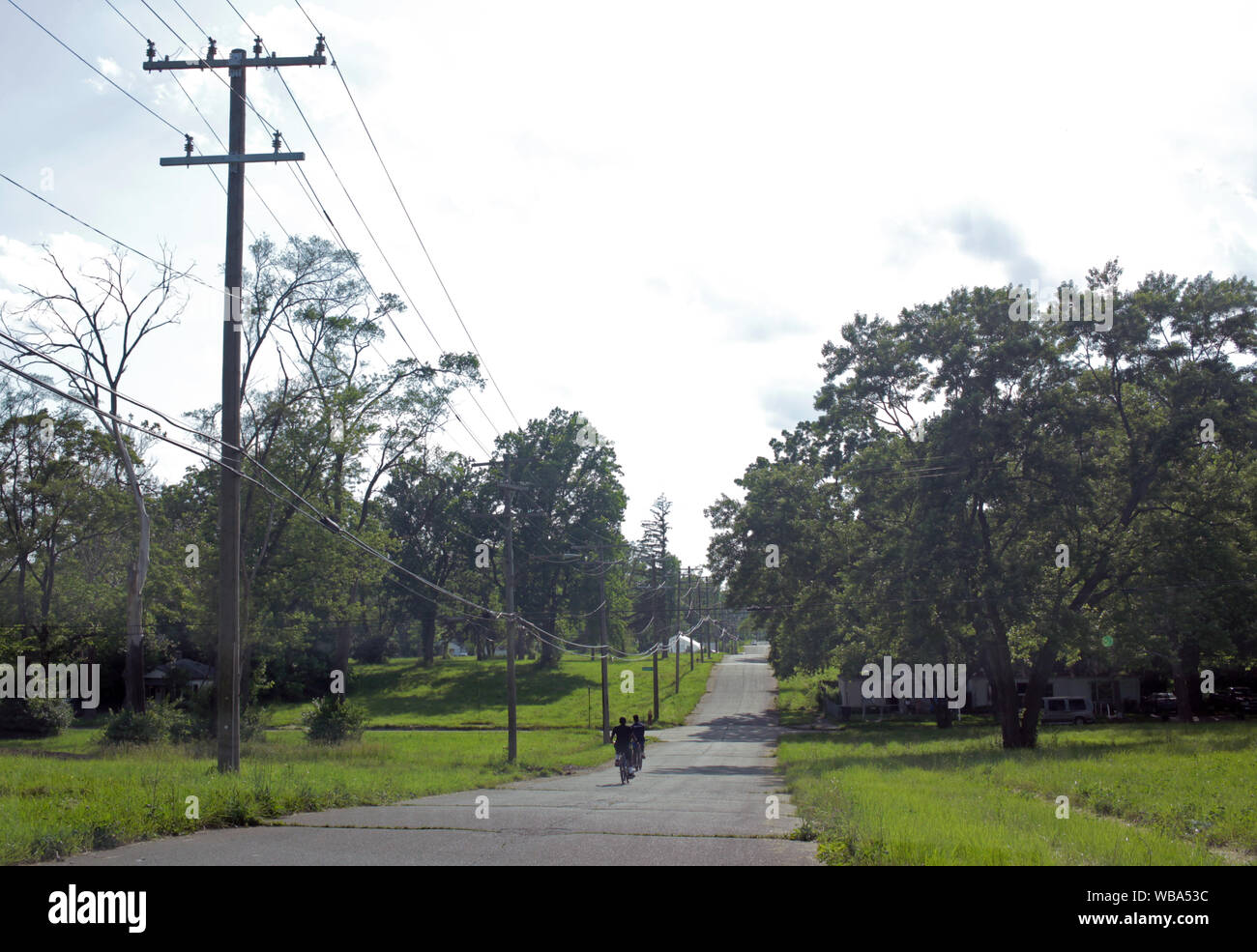 Two men cycle down a street in Brightmoor, Detroit, MIchigan,USA Stock ...