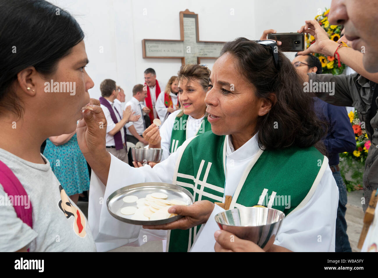 A newly ordained Lutheran pastor gives a communion wafer to a ...
