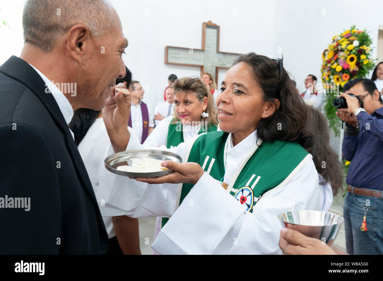 A newly ordained Lutheran pastor gives a communion wafer to a ...
