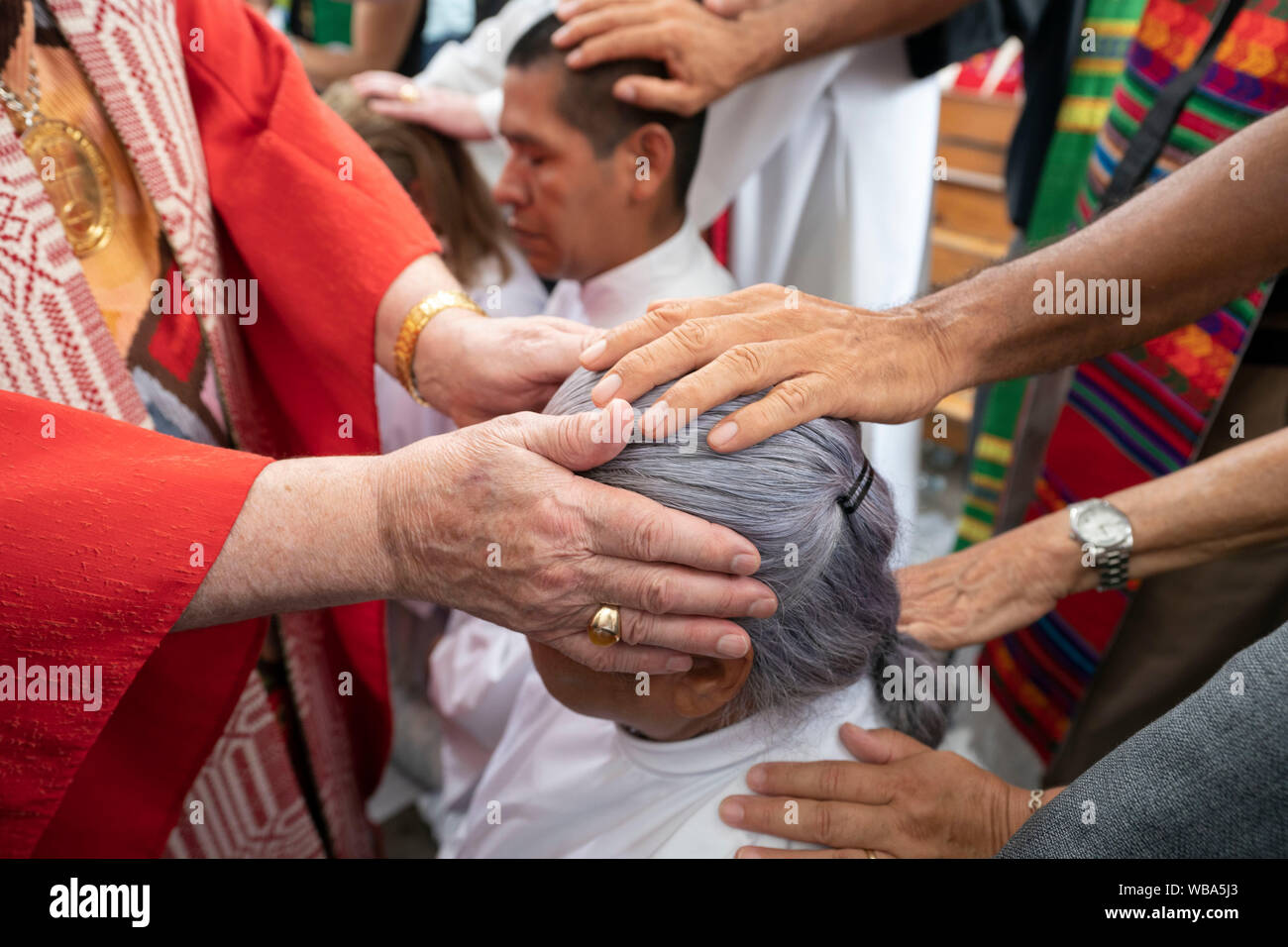 Traditional laying on of hands blessing during ordination ceremony for ...