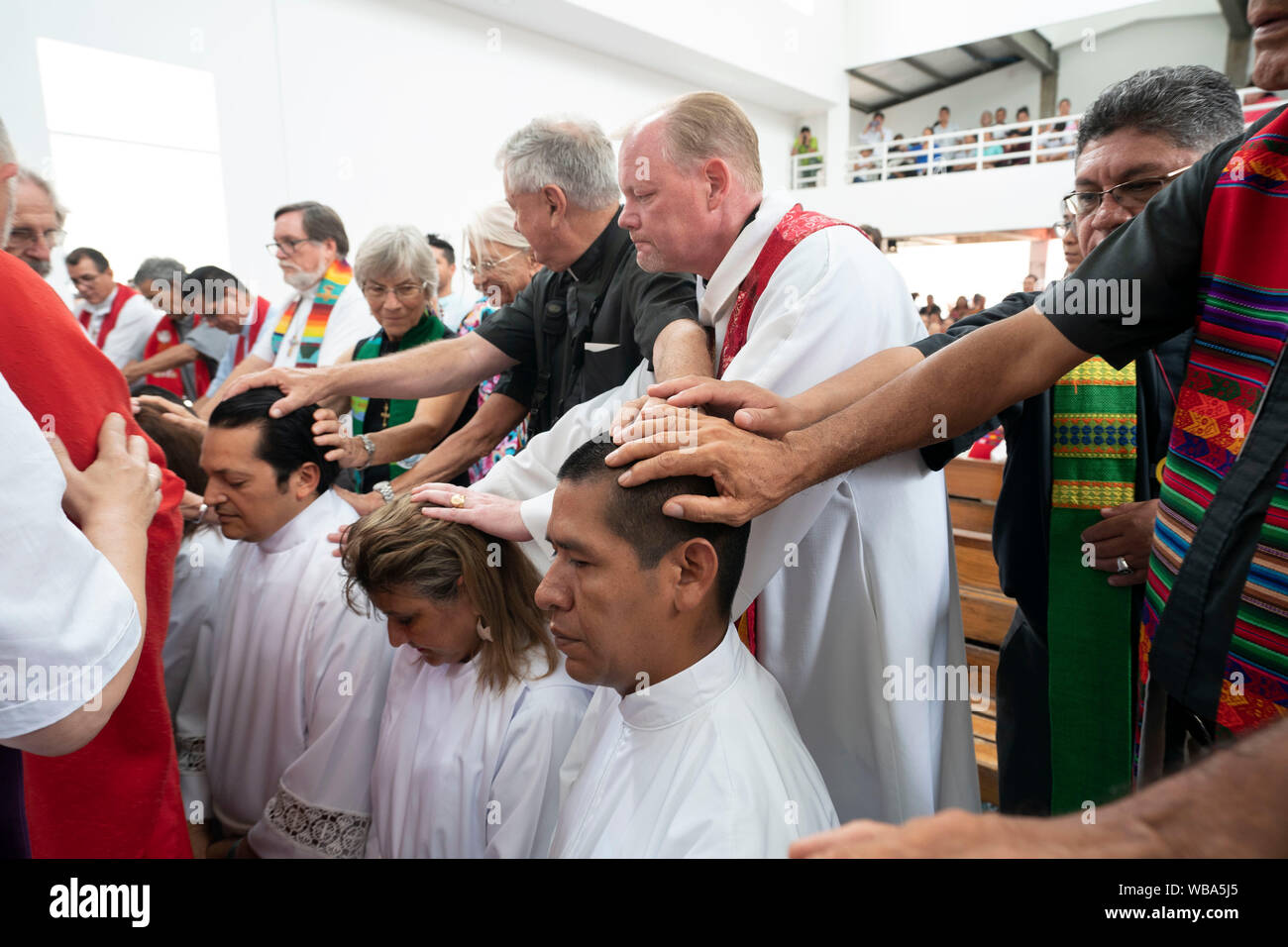 Traditional laying on of hands blessing during ordination ceremony for ...