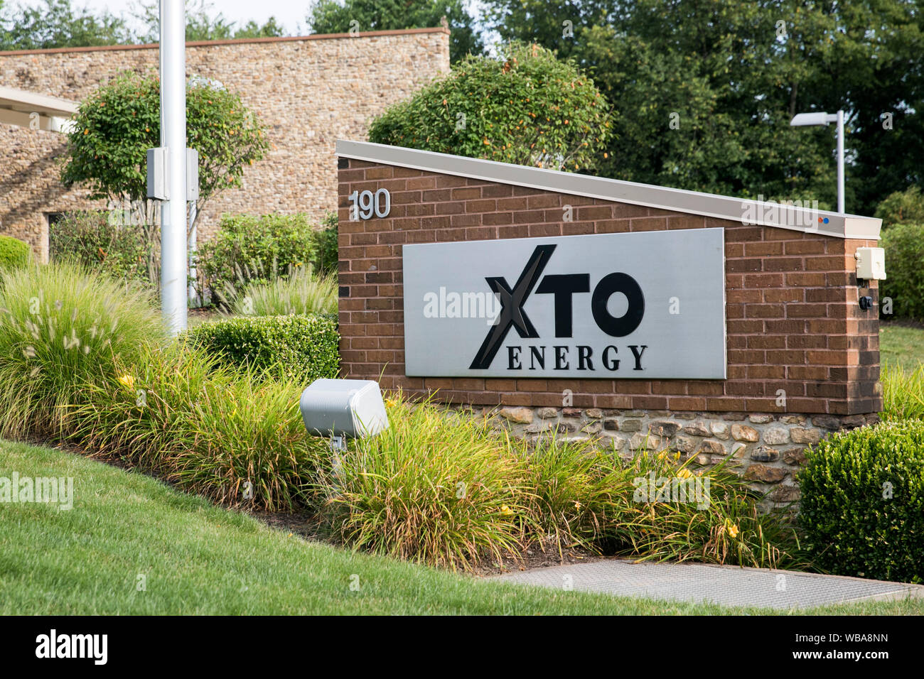A logo sign outside of a facility occupied by XTO Energy, Inc., in ...