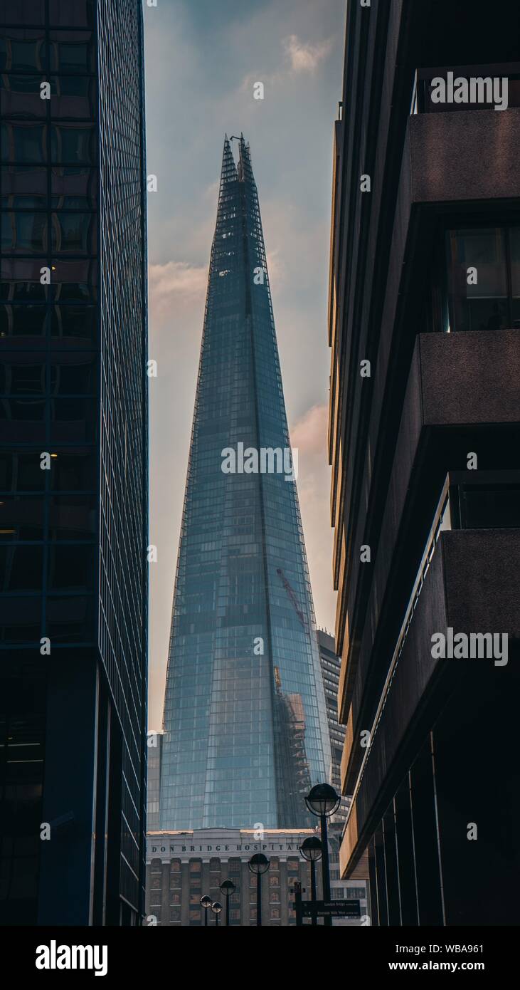 Vertical low angle shot of the Shard skyscraper between buildings in ...