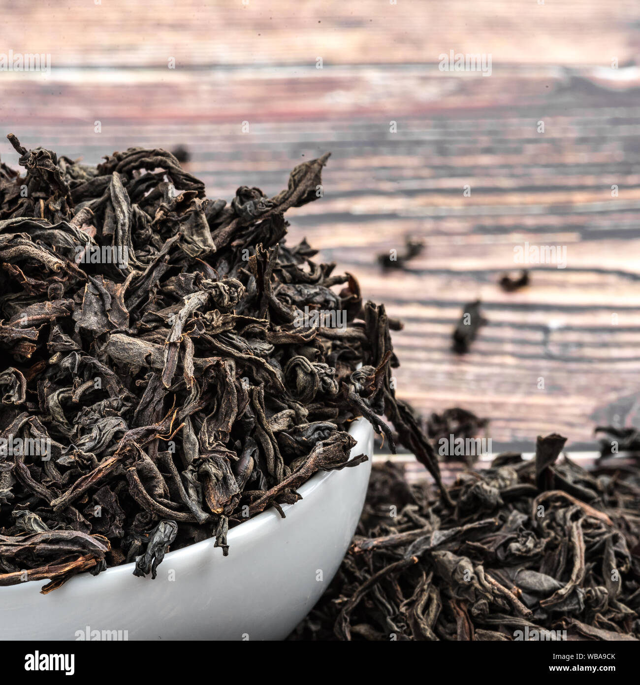 Dried tea is poured into a ceramic cup on a wooden plank table Stock ...