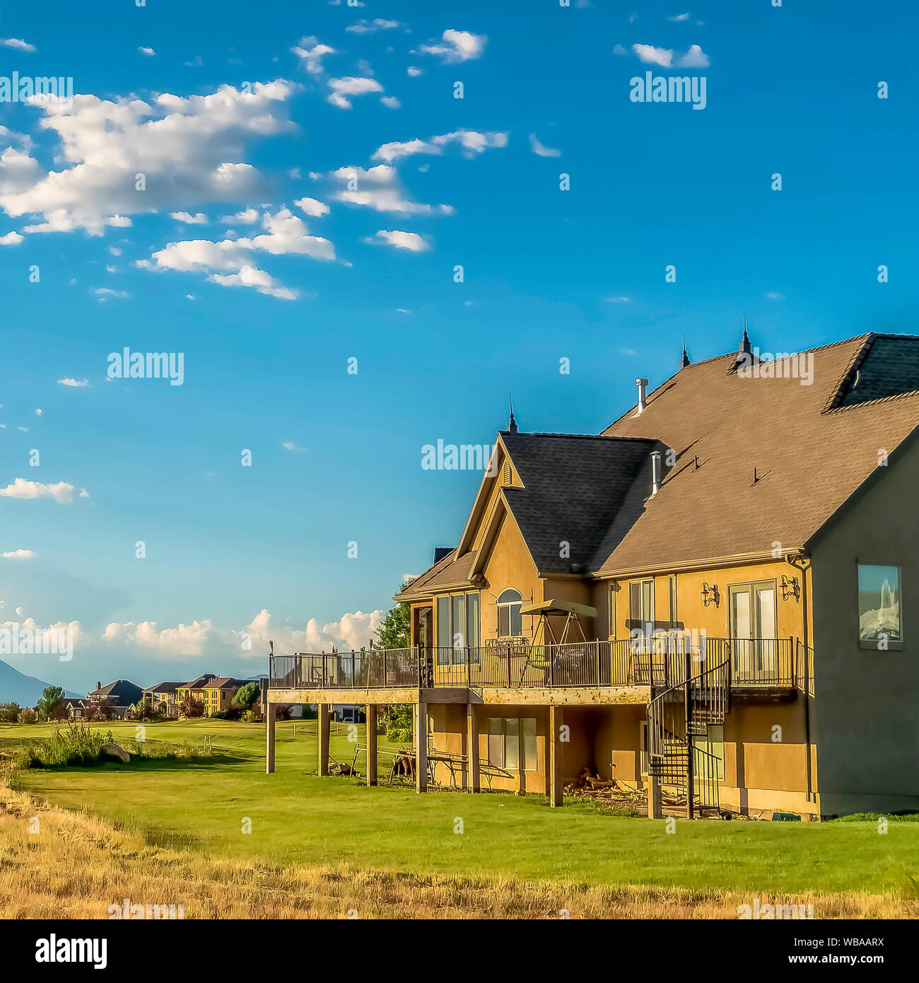 Square frame Scenic landscape with homes on a grassy terrain under blue ...