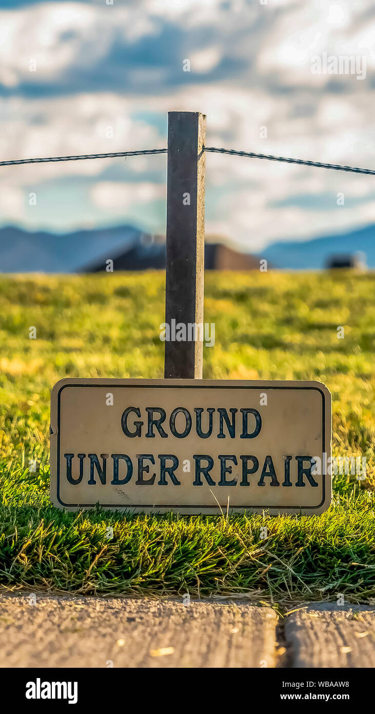 Vertical frame Close up of a Ground Under Repair sign on a grassy ...