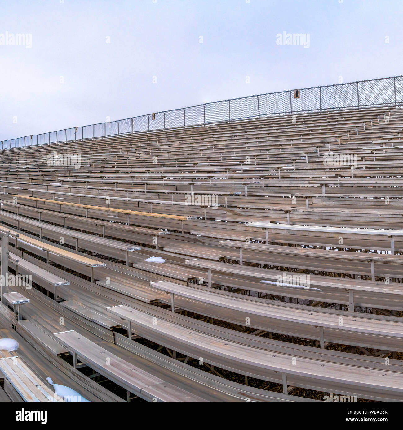 Square frame Row of tiered benches on a sports arena under a cloudy sky ...