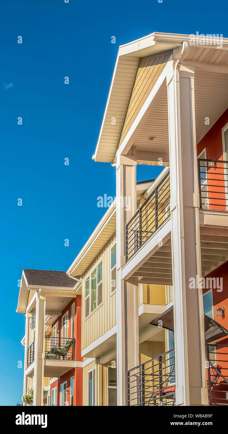 Vertical House exterior with small balconies and combination of white ...