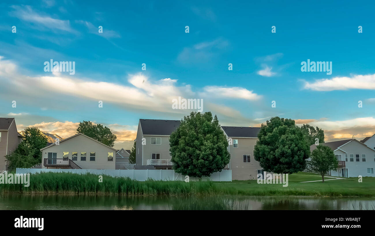 Panorama frame Pathway along a shiny pond on a grassy terrain with ...