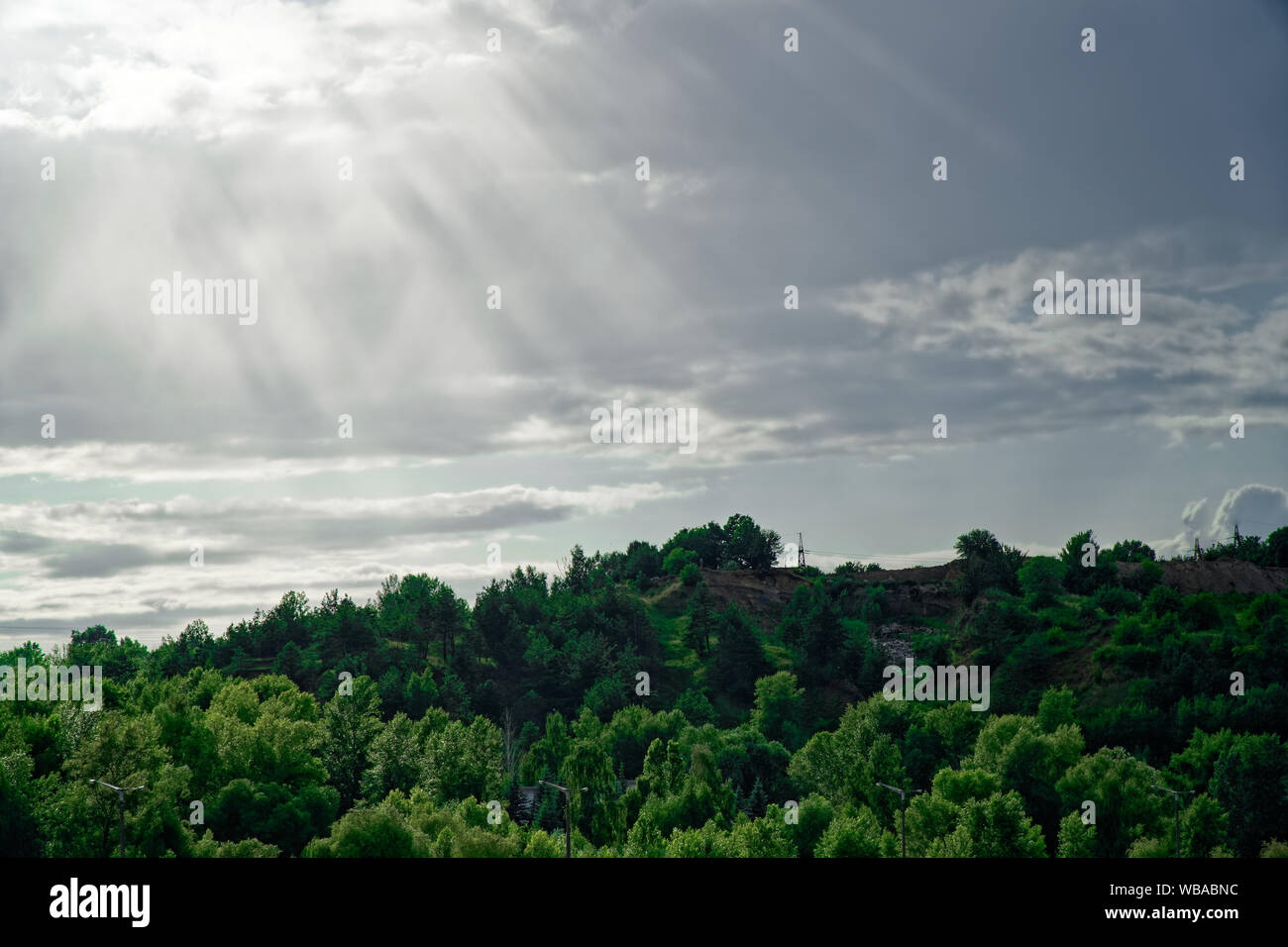 Rays of bright sun peep out from behind dark clouds, sun break after ...