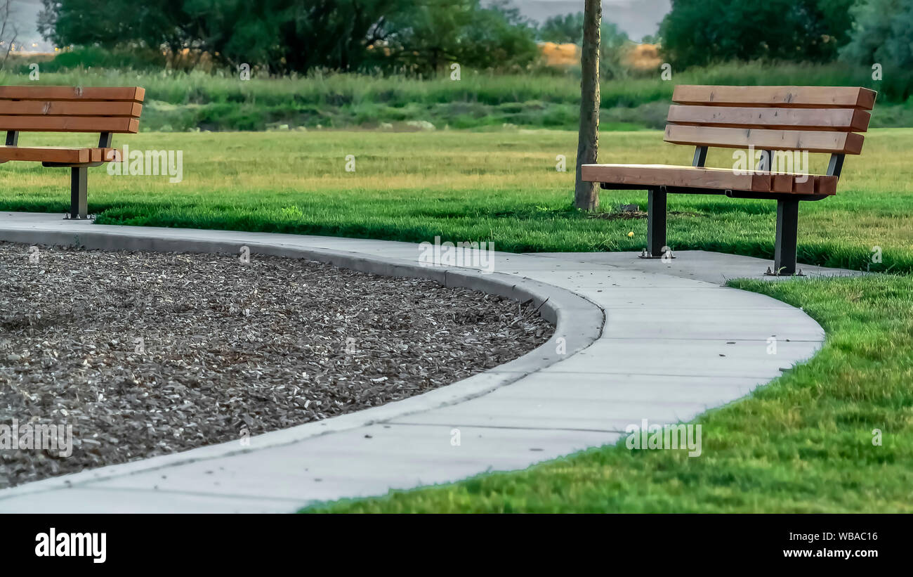 Panorama Bench and circular pathway on a grass covered terrain gainst ...