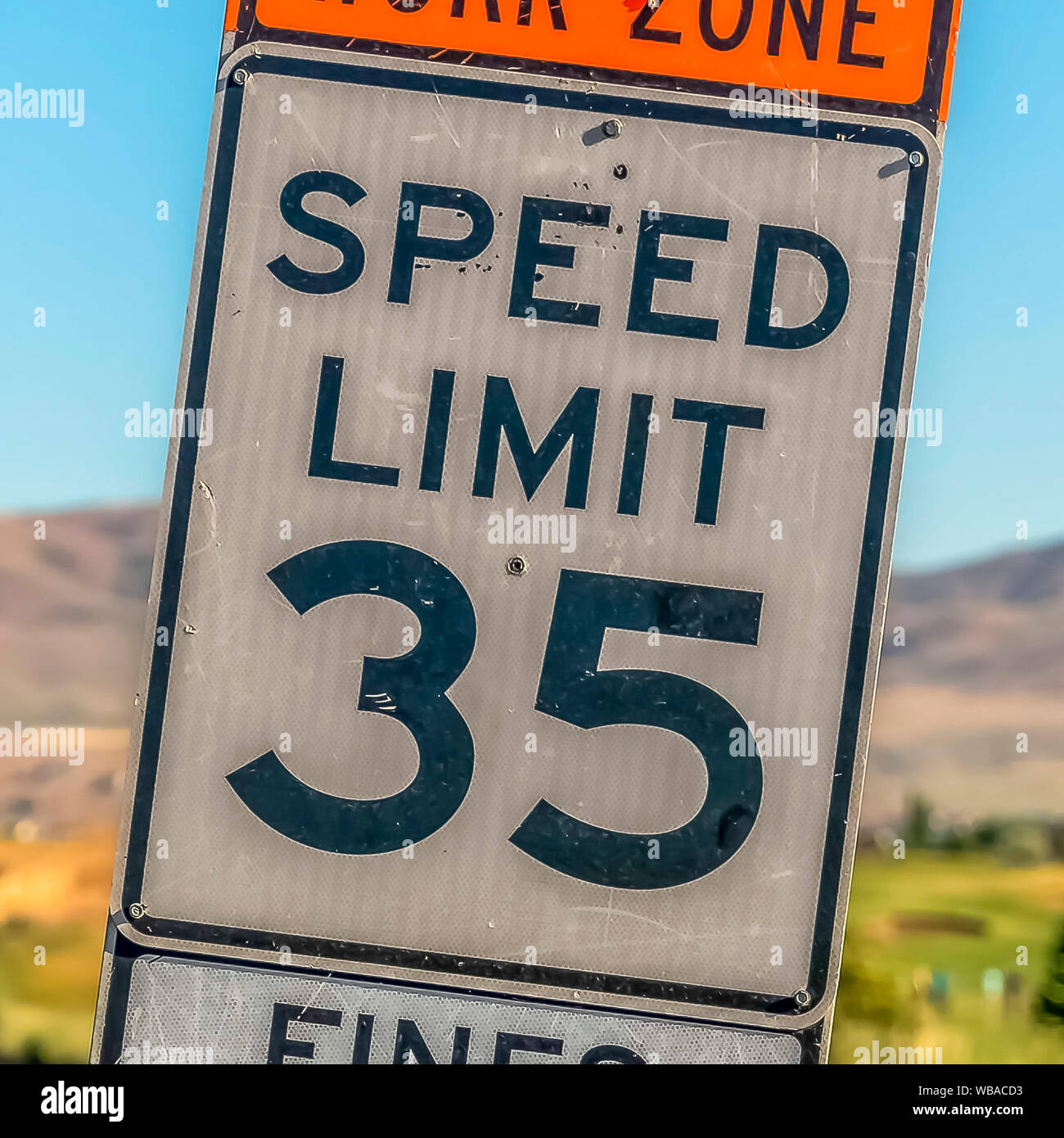 Square Close up of speed limit sign against dry ground mountain and sky ...