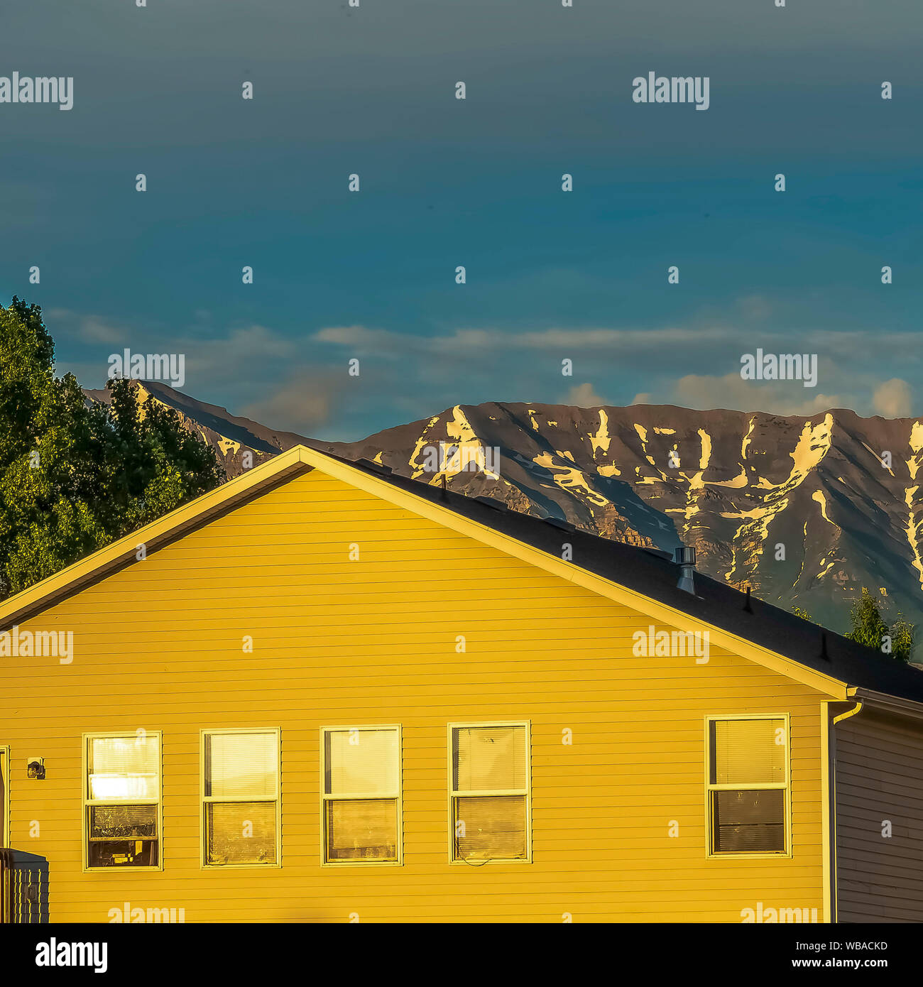 Square frame Sunlit house with cream wall and small wooden balcony ...