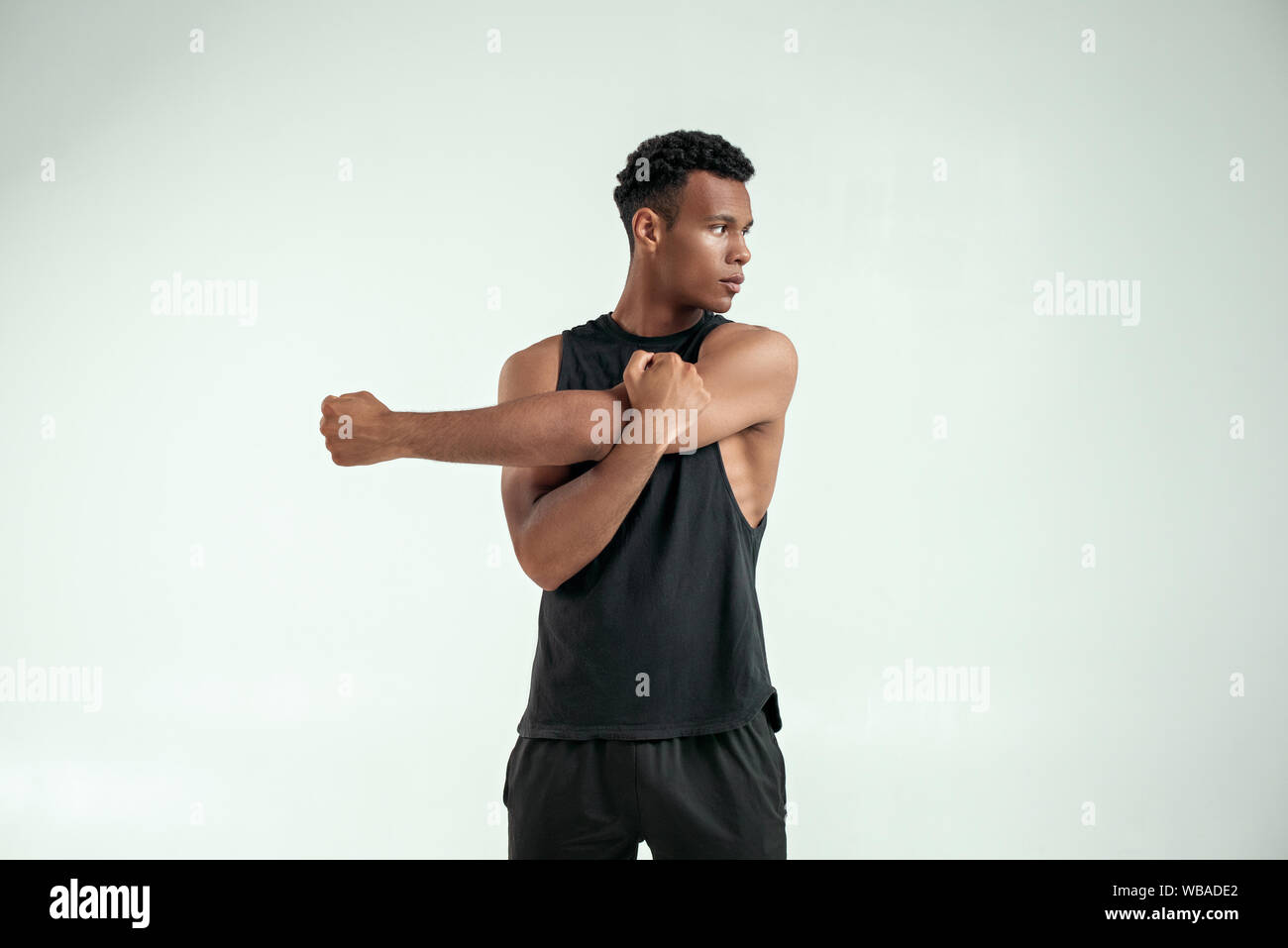 Important stretching. Strong young afro american man stretching his arm ...